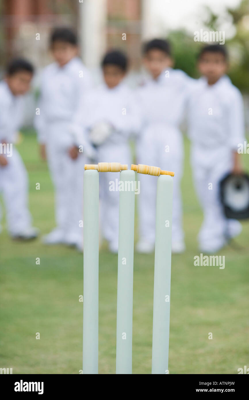 Close-up of cricket stump with cricket players standing in the ...
