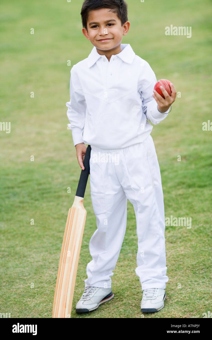 Boy holding a cricket bat and a cricket ball Stock Photo - Alamy