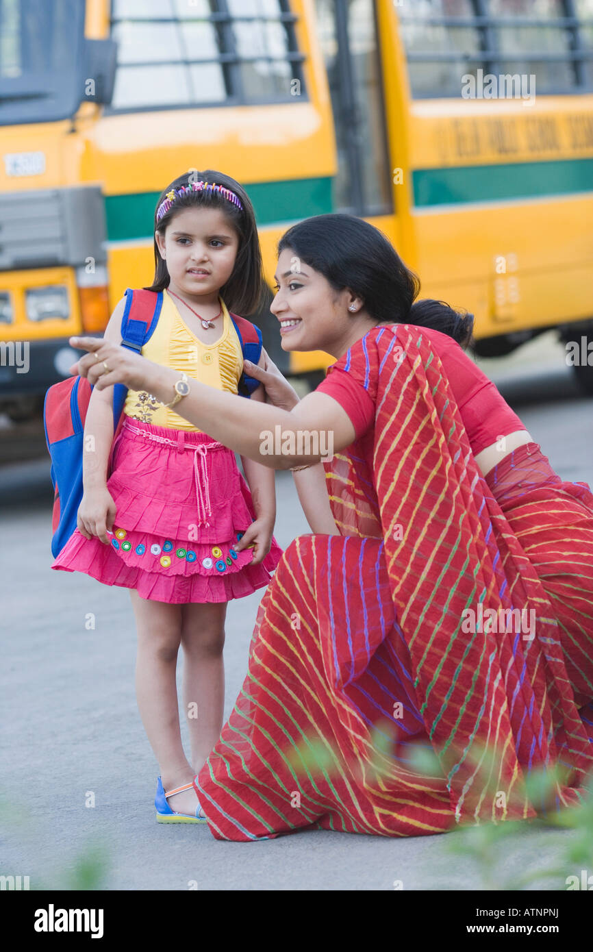 School teacher pointing forward with her student standing beside her ...