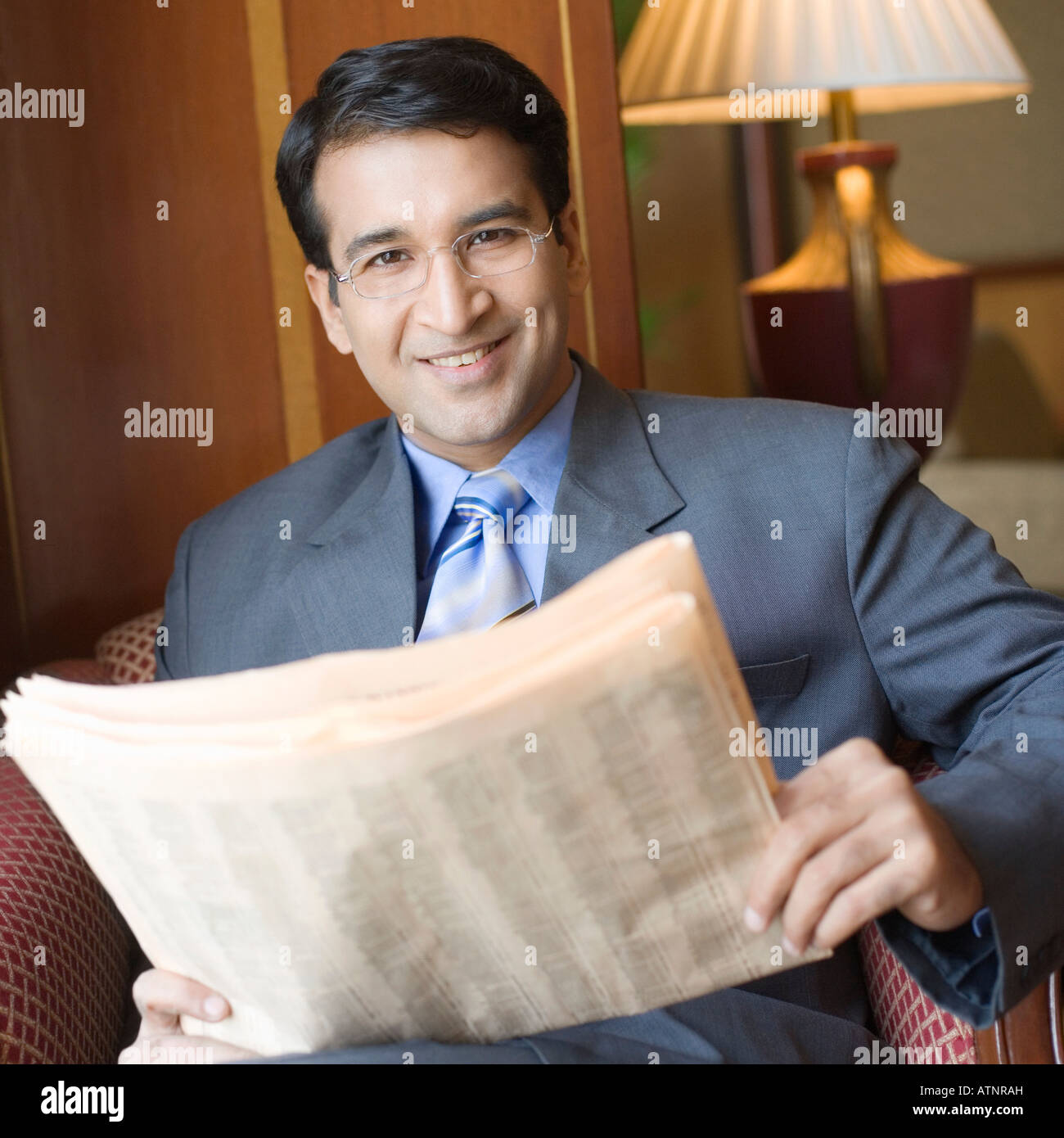 Portrait of a businessman holding a newspaper and smiling Stock Photo ...