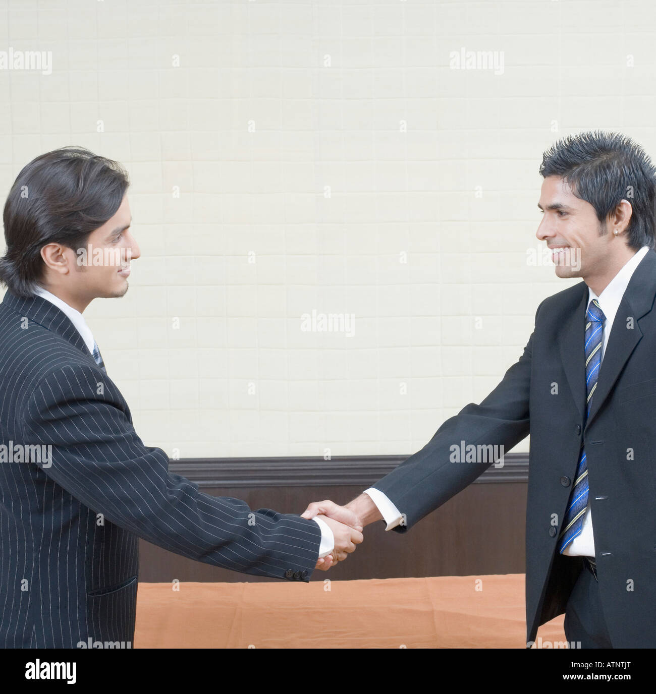 Two businessmen shaking hands and smiling Stock Photo - Alamy