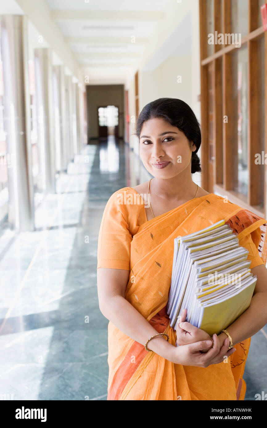 Portrait of a school teacher carrying a stack of books Stock Photo - Alamy