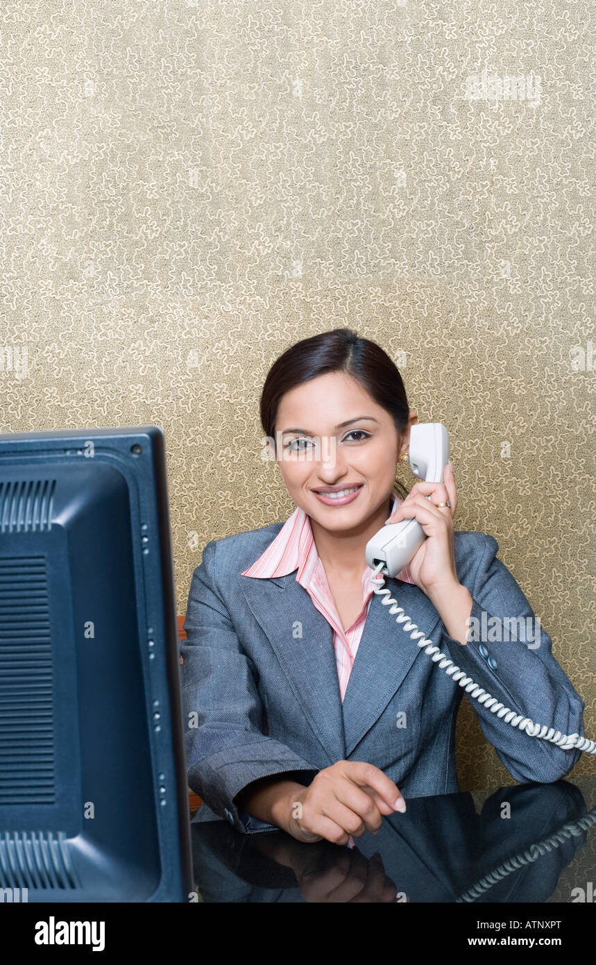 Sitting smiling authority looking at camera landline phone technology ...