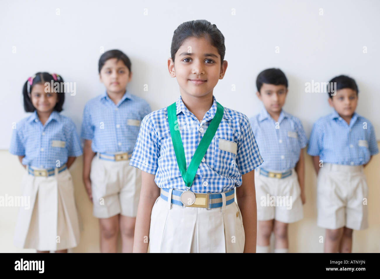 Portrait of a schoolgirl with a medal around her neck with her ...