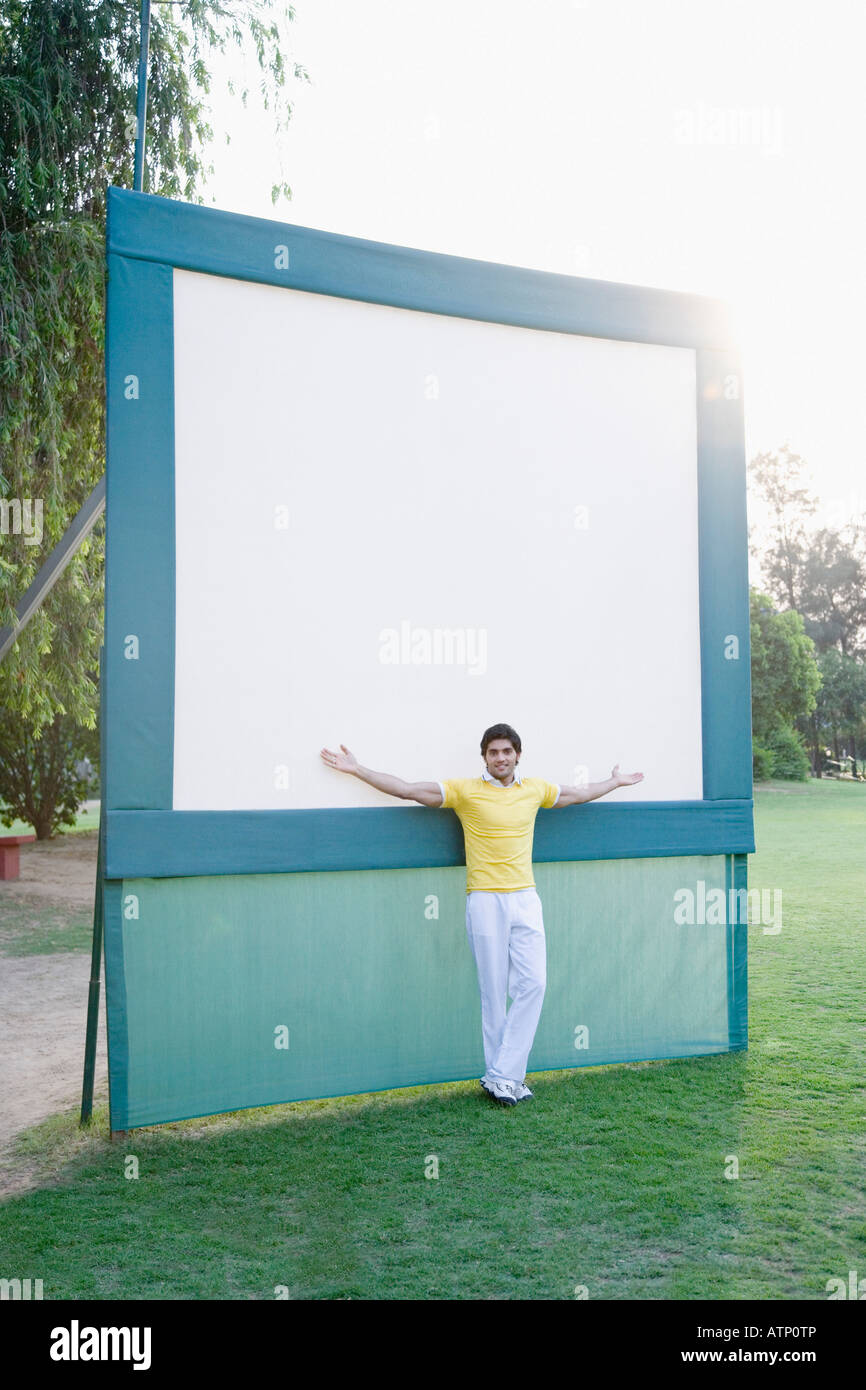 Young man standing with his arms outstretched in front of a visual ...