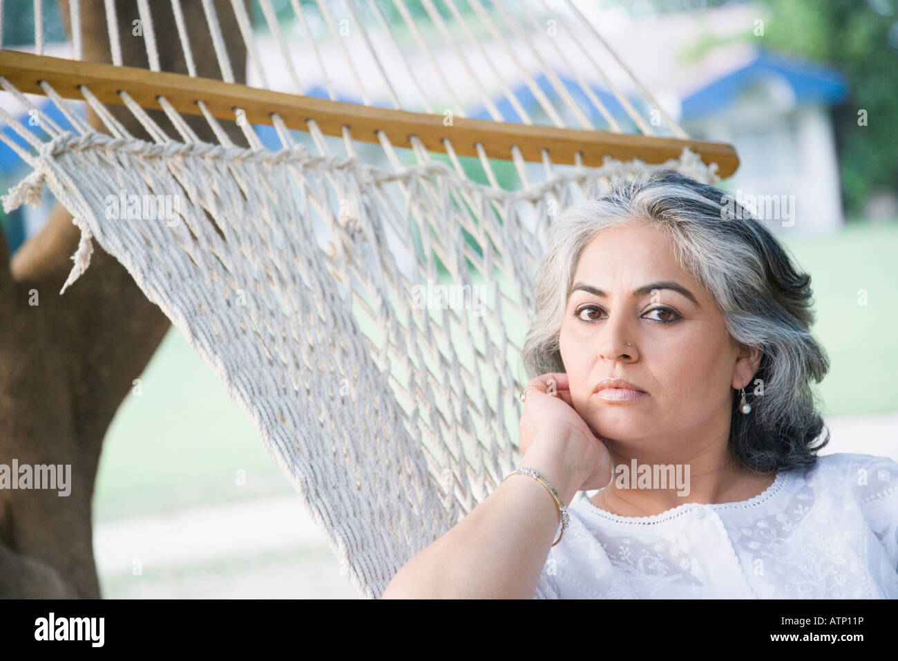 Portrait of a mature woman reclining in a hammock and thinking Stock ...