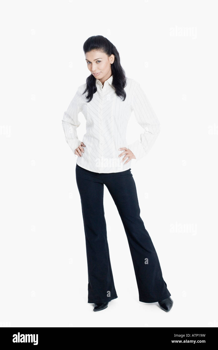 Portrait of a young woman standing with arms akimbo Stock Photo - Alamy