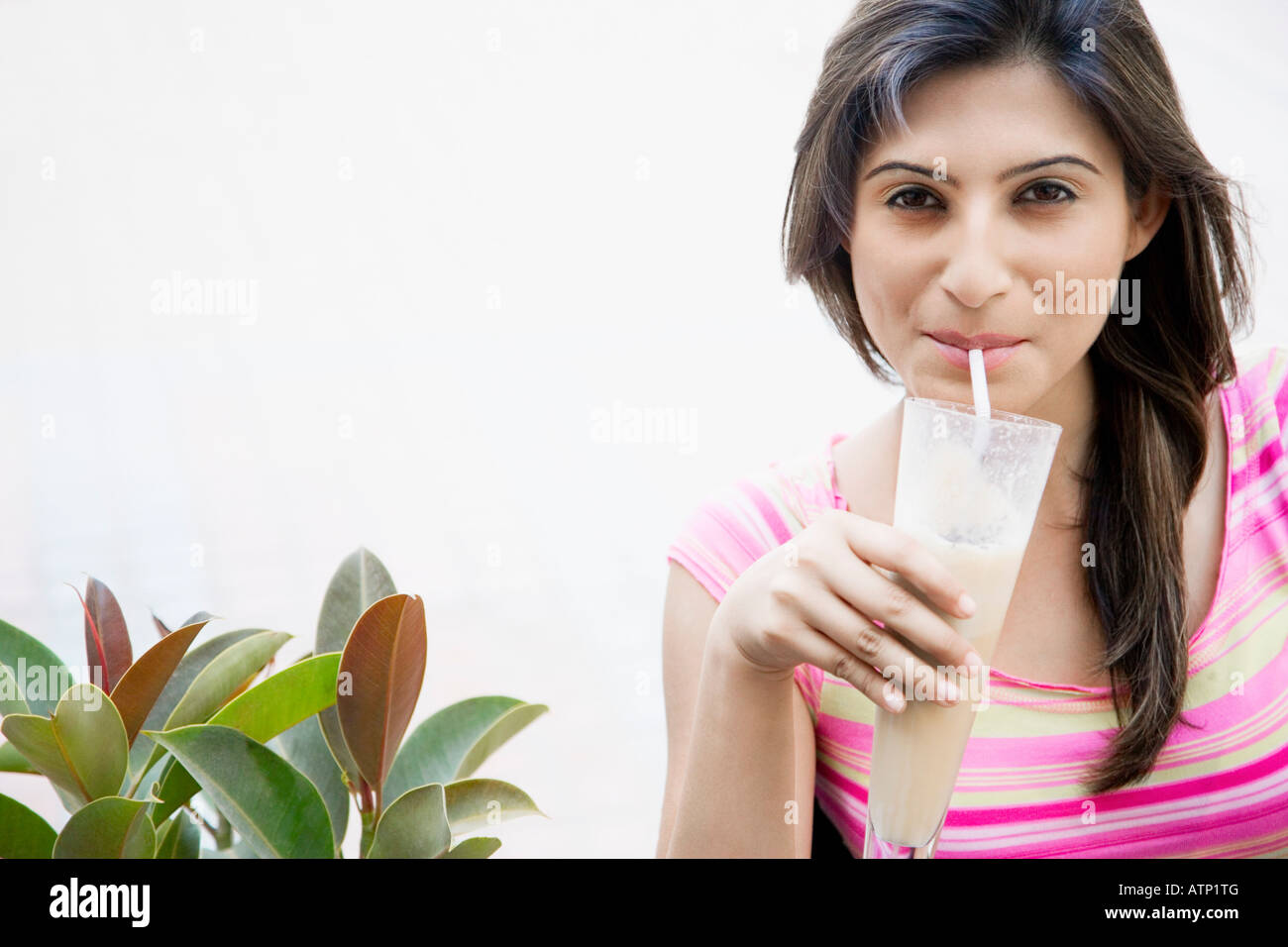 Portrait of a young woman drinking milkshake Stock Photo - Alamy