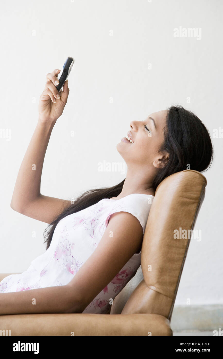 Side profile of a young woman text messaging and smiling Stock Photo ...