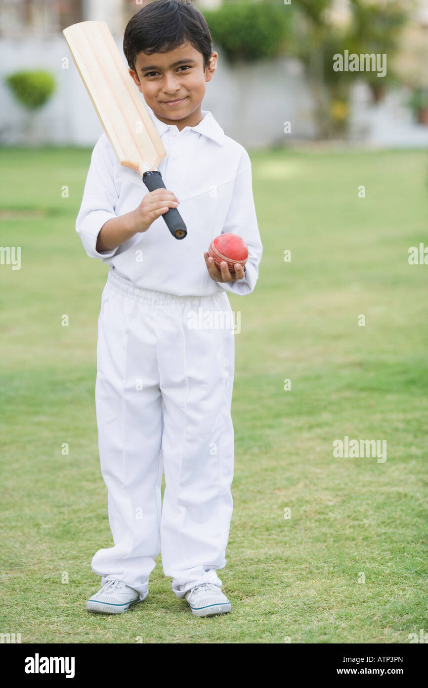 Portrait of a boy holding a cricket bat and a cricket ball Stock Photo ...