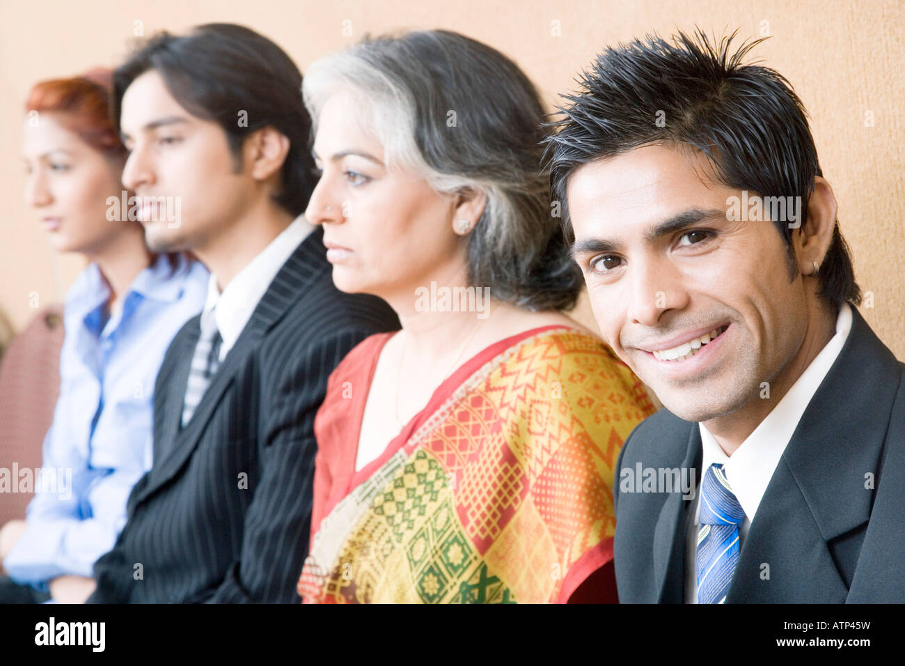 Portrait of a businessman sitting with three business executives and ...