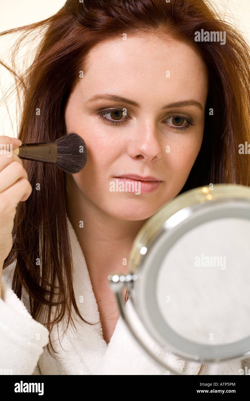Woman putting on makeup Stock Photo - Alamy