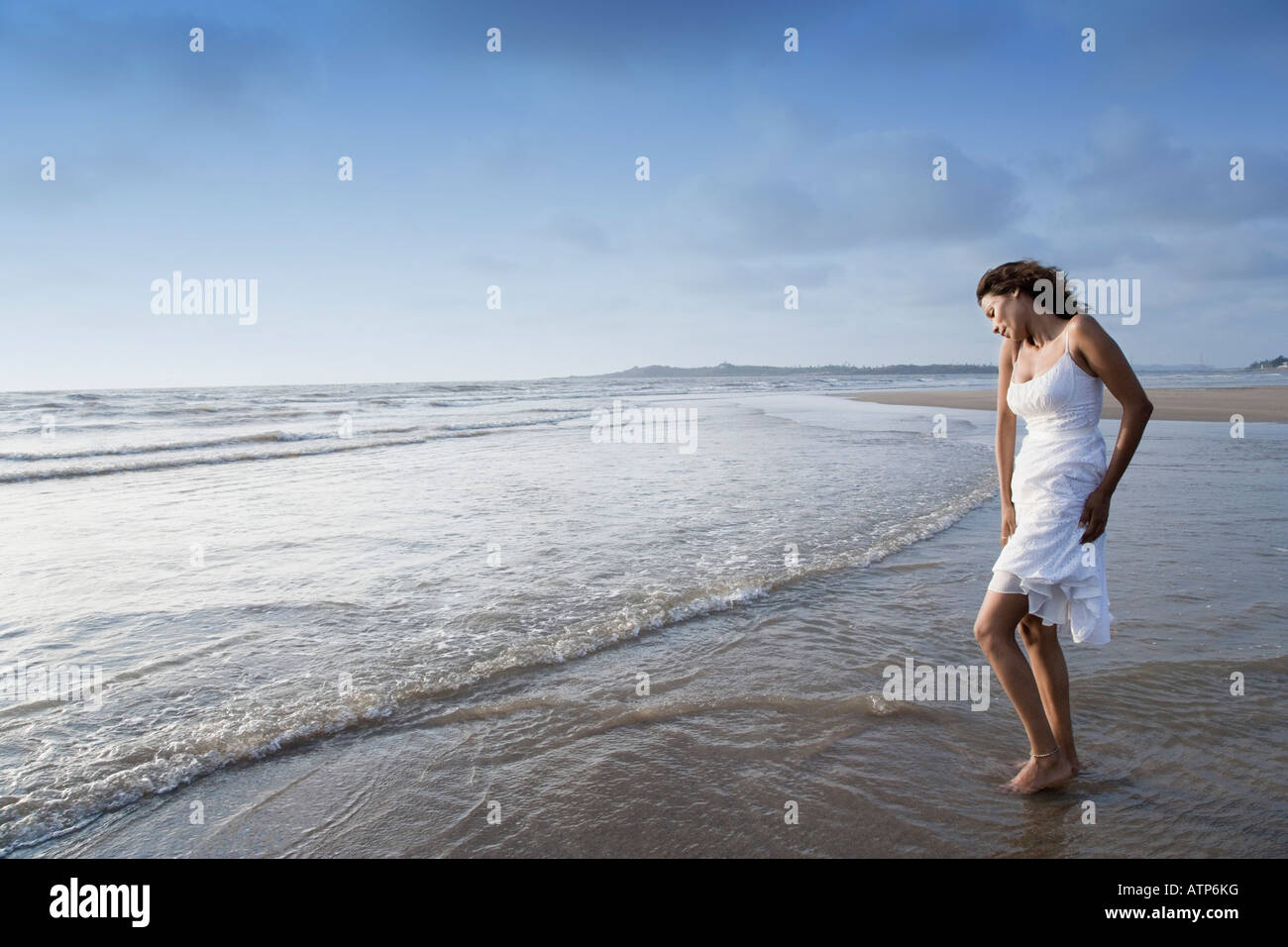 Side profile of a young woman standing on the beach Stock Photo - Alamy