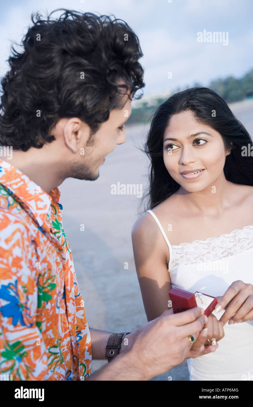 Young man giving a ring to a young woman Stock Photo - Alamy