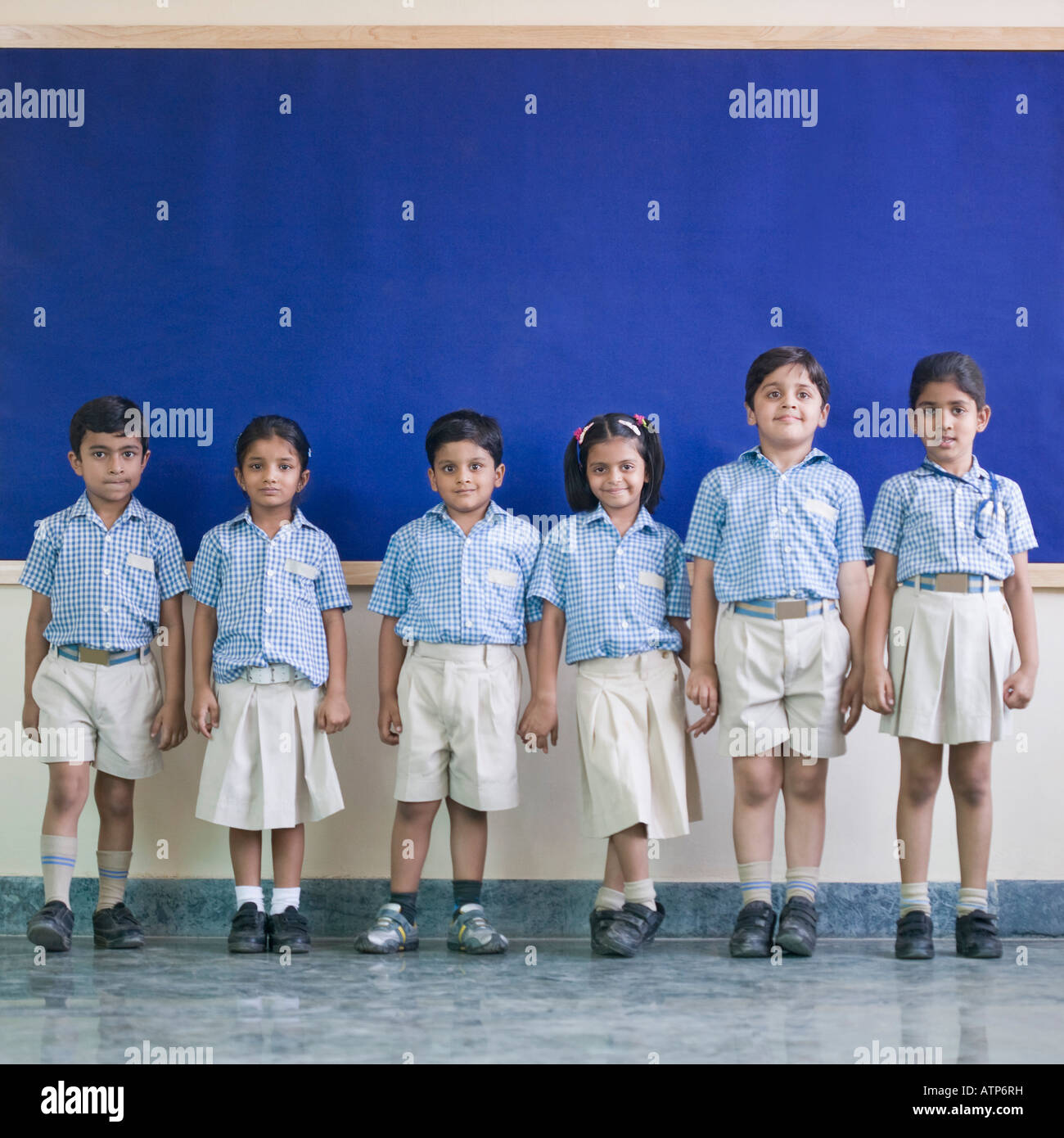 Group of students standing in front of a blackboard and smiling Stock ...
