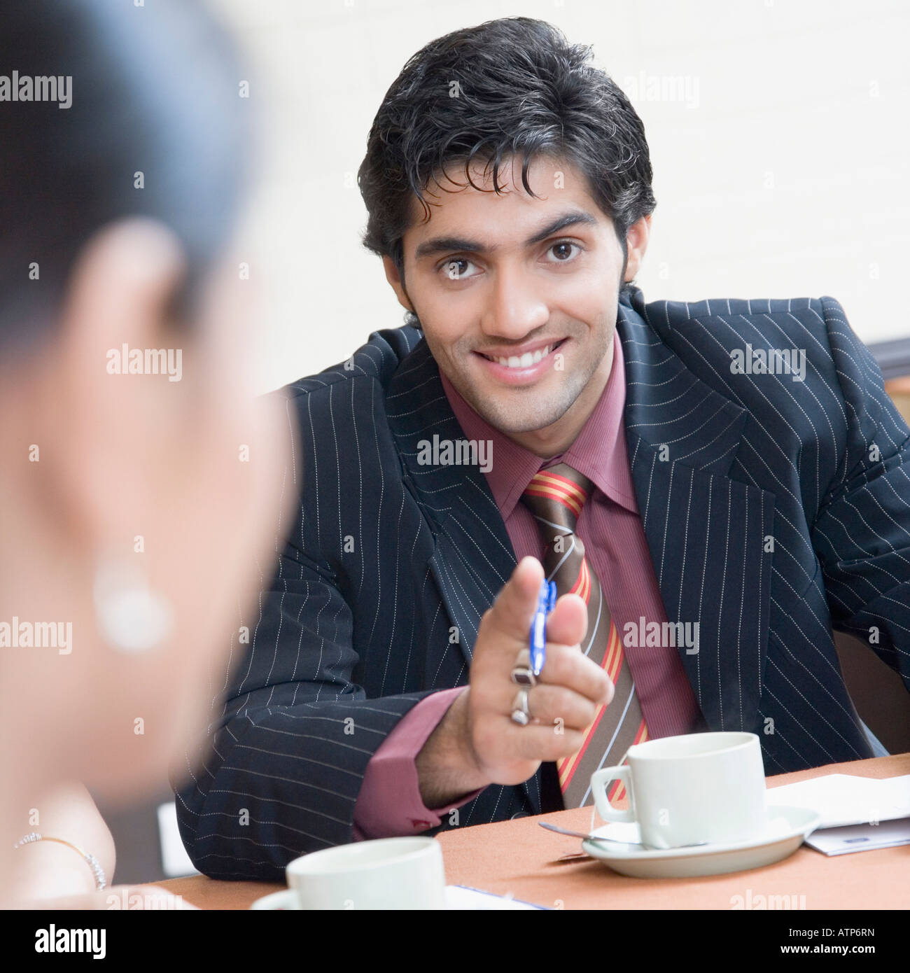 Portrait of a businessman pointing forward and smiling Stock Photo - Alamy