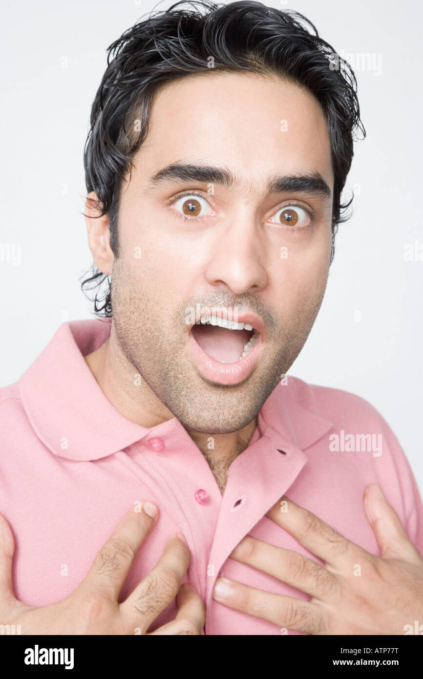 Portrait of a young man looking surprised Stock Photo - Alamy