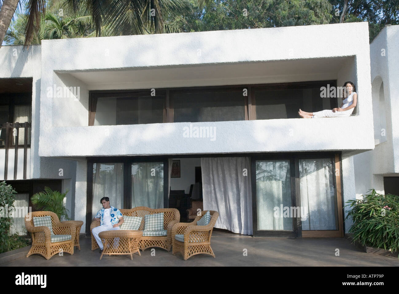Young man sitting on a couch in front of a building Stock Photo - Alamy