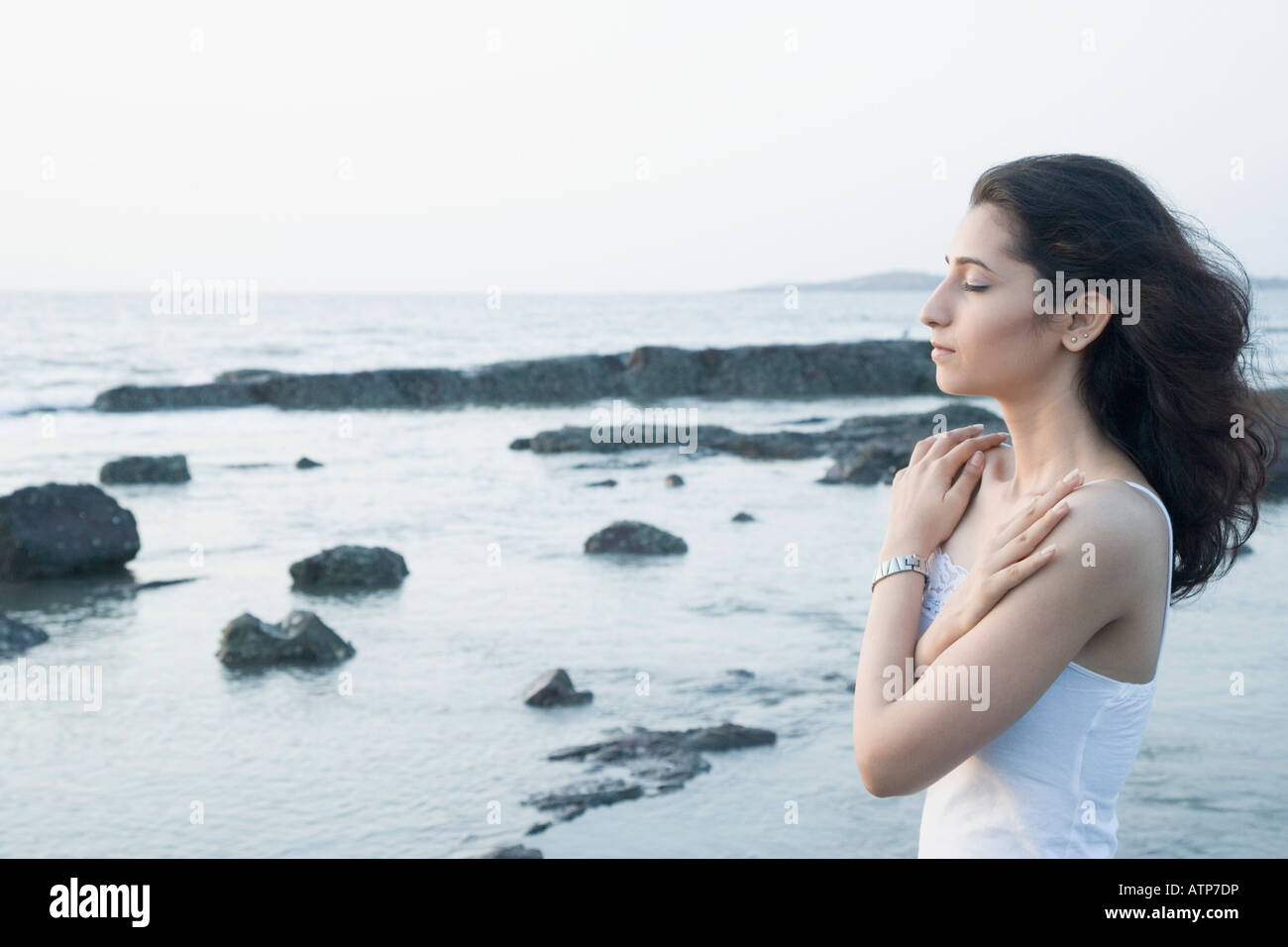 Side profile of a young woman hugging herself on the coast Stock Photo ...