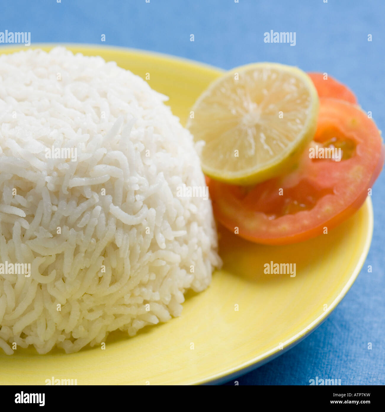 Close-up of white rice in a plate with slices of lemon and tomato Stock ...