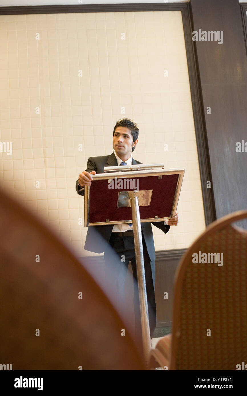 Businessman standing at a lectern Stock Photo - Alamy