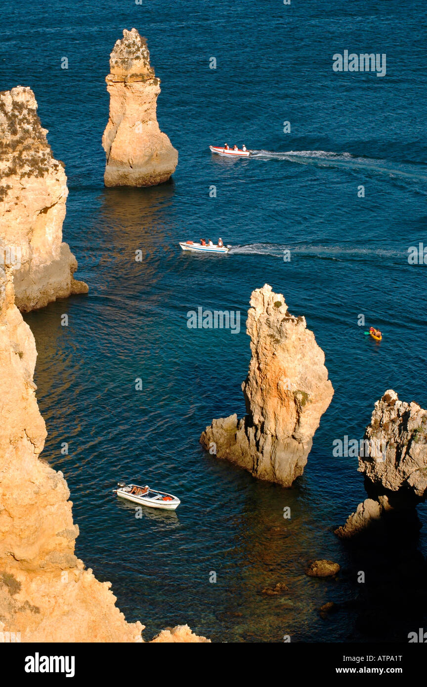 Boat tours boating amid the sea formation rocks and cliffs at Ponta da ...