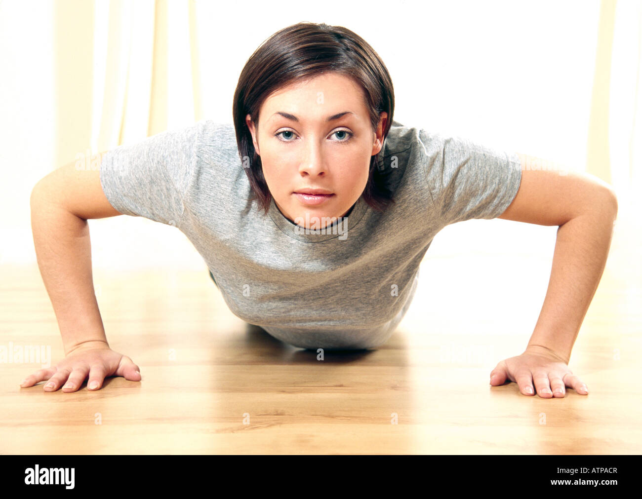Young woman doing press ups at home Stock Photo - Alamy