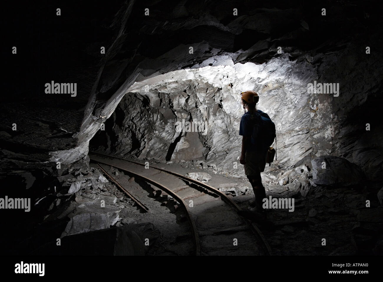 Female mine explorer with an abandoned railway in slate mine North ...