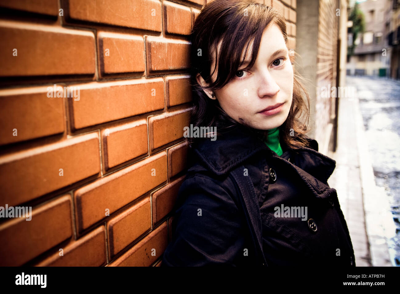Beautiful girl waiting against brick wall Stock Photo - Alamy