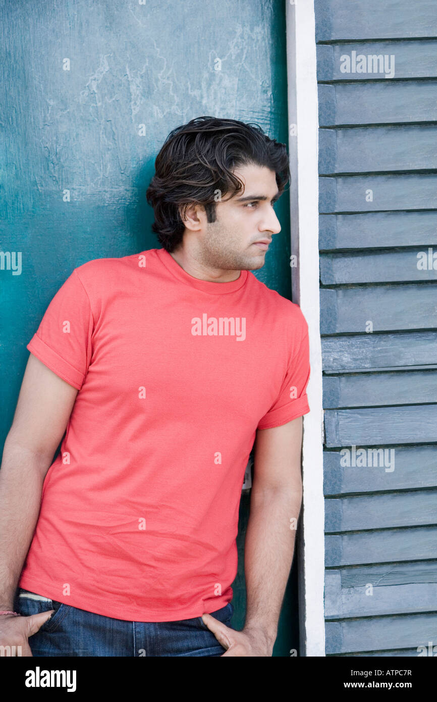 Young man leaning against a door Stock Photo - Alamy