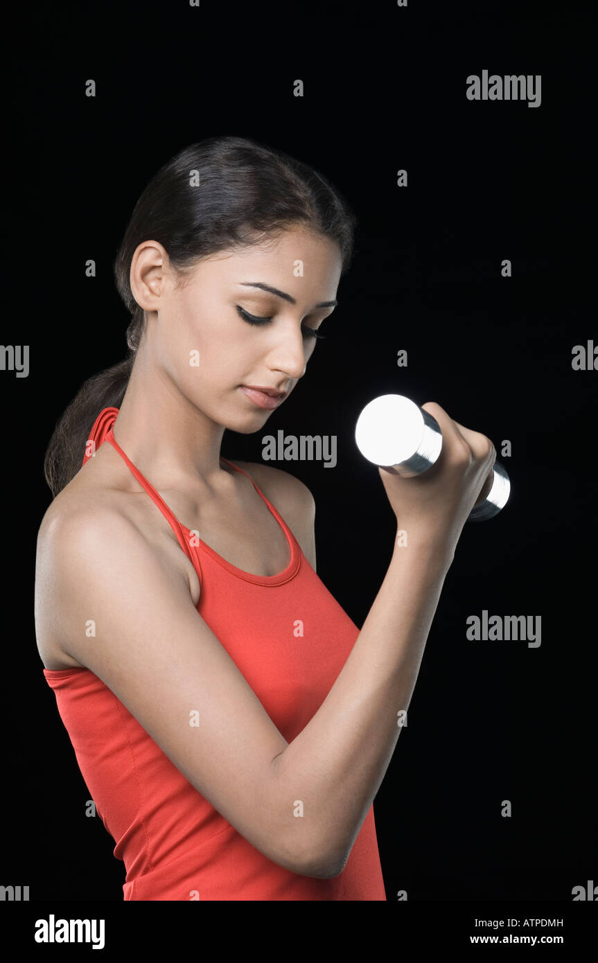 Side profile of a young woman exercising with a dumbbell Stock Photo ...