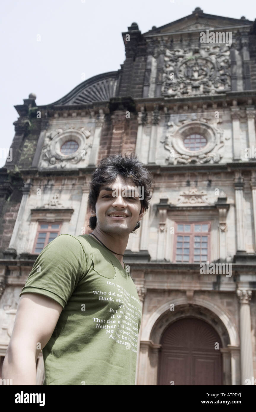 Portrait of a young man smiling in front of a building, Goa, India ...