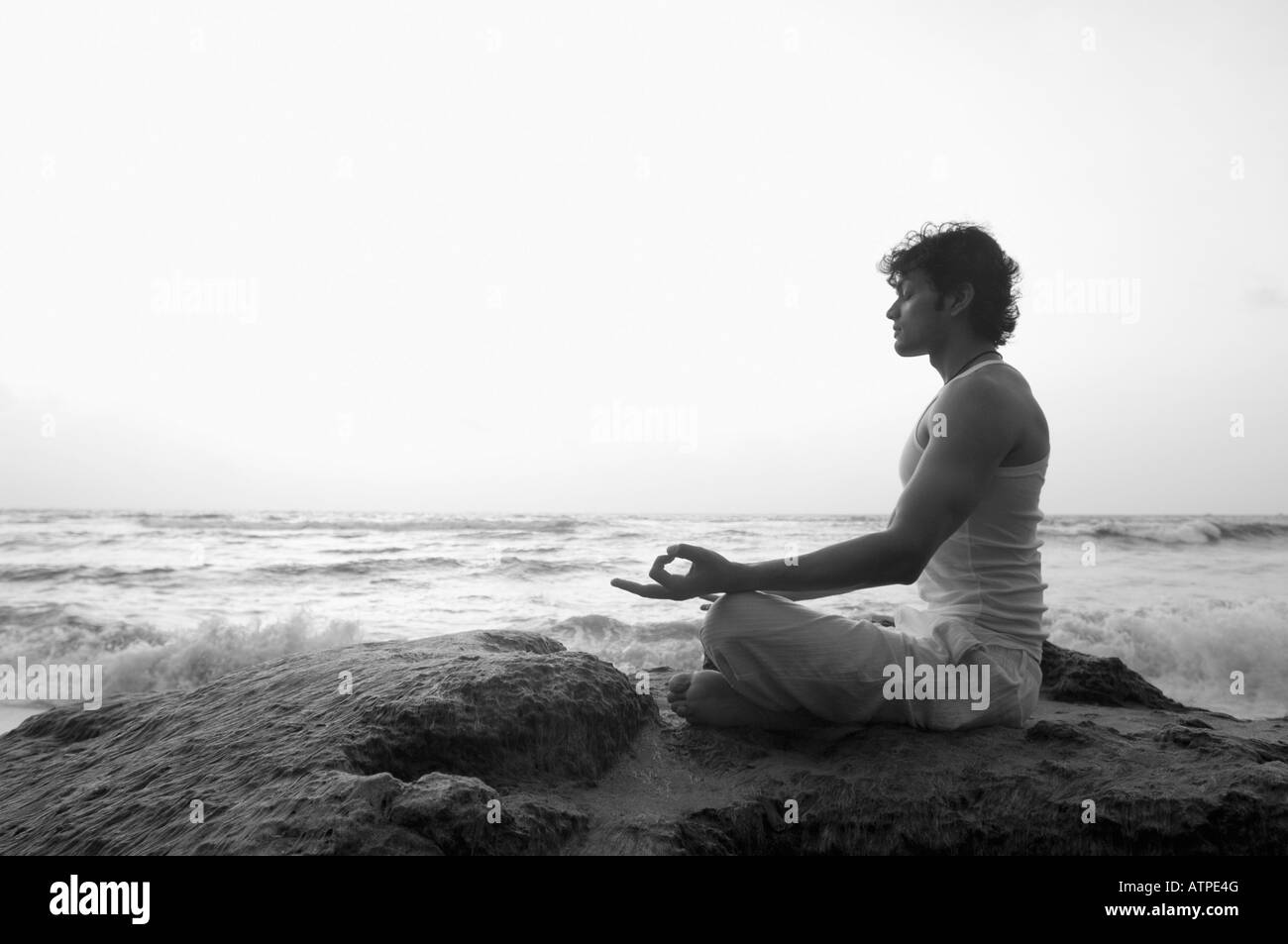 Side profile of a young man meditating on the beach Stock Photo - Alamy