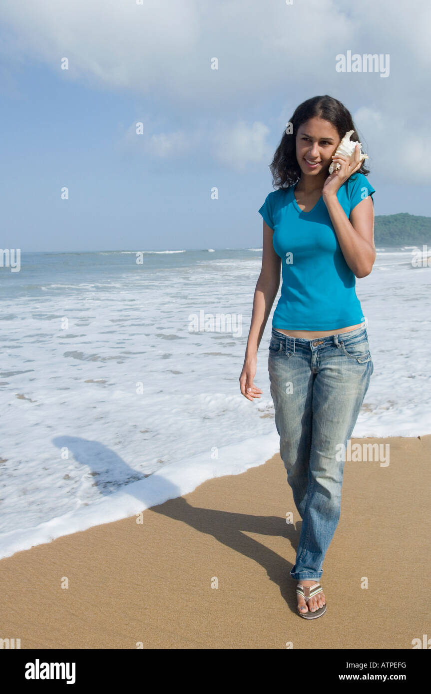 Woman holding conch shell ear hi-res stock photography and images - Alamy