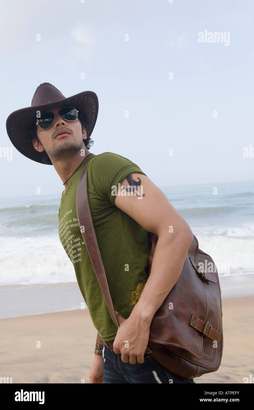 Side profile of a young man walking on the beach Stock Photo - Alamy