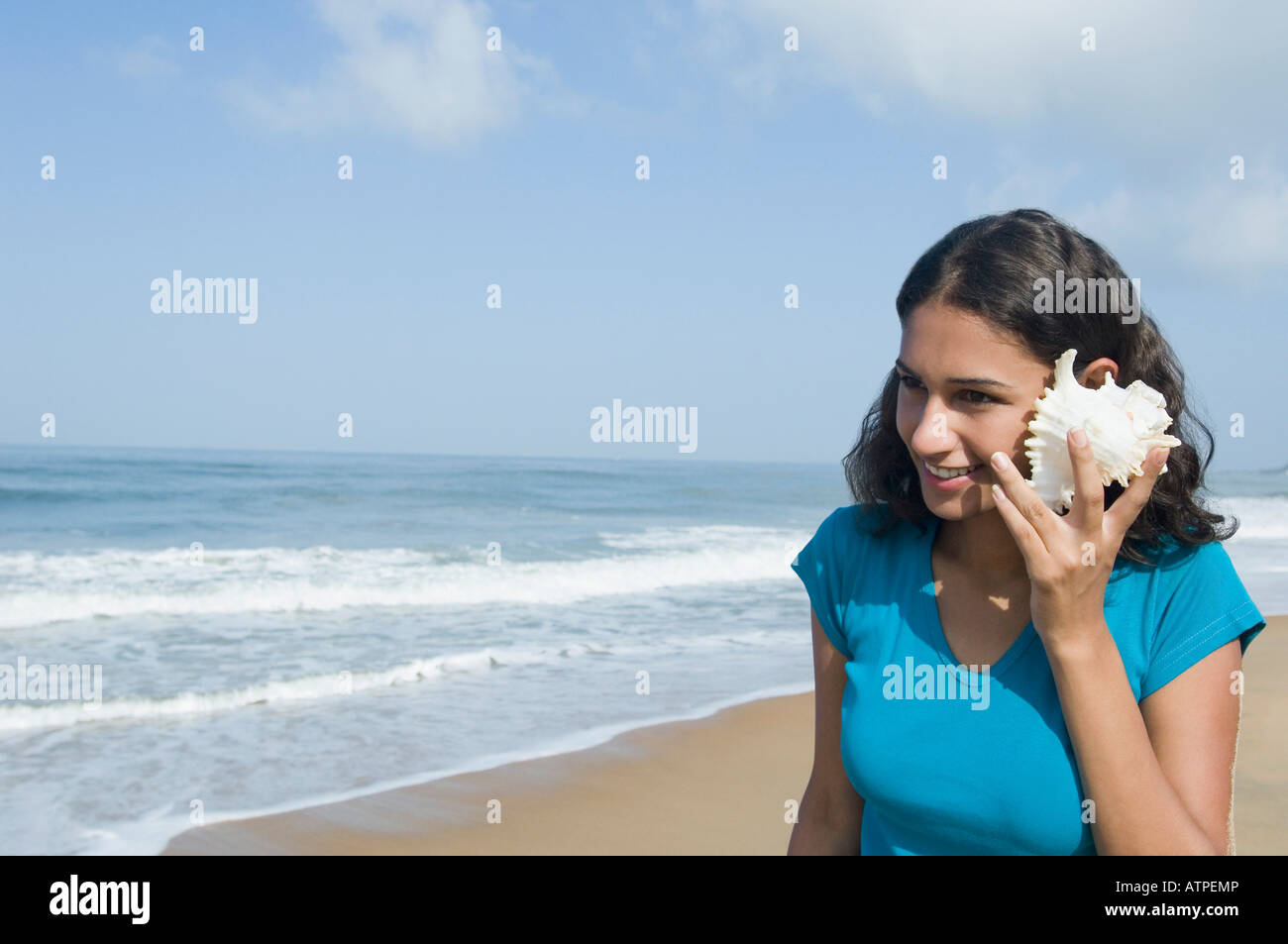 Woman holding conch shell ear hi-res stock photography and images - Alamy