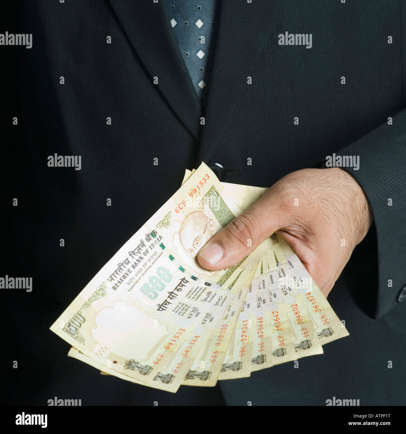 Mid section view of a businessman holding Indian five hundred rupee ...