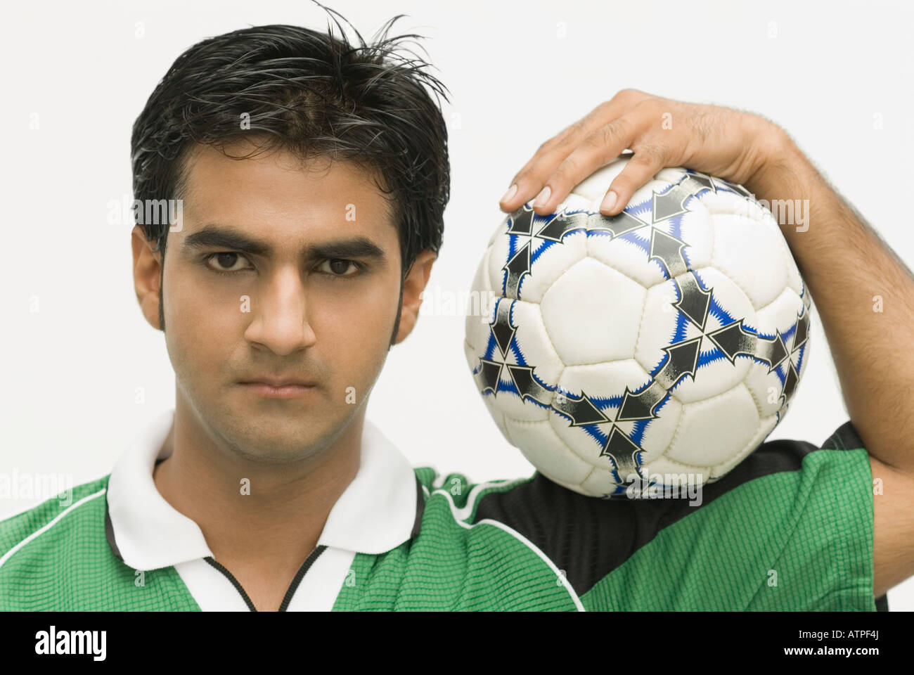 Portrait of a young man carrying a soccer ball on his shoulder Stock ...