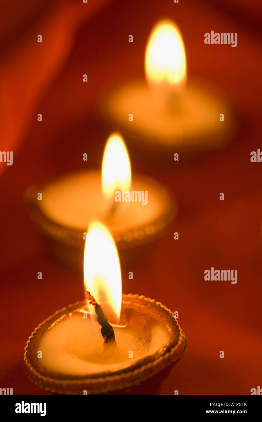 Close-up of a row of lit oil lamps Stock Photo - Alamy