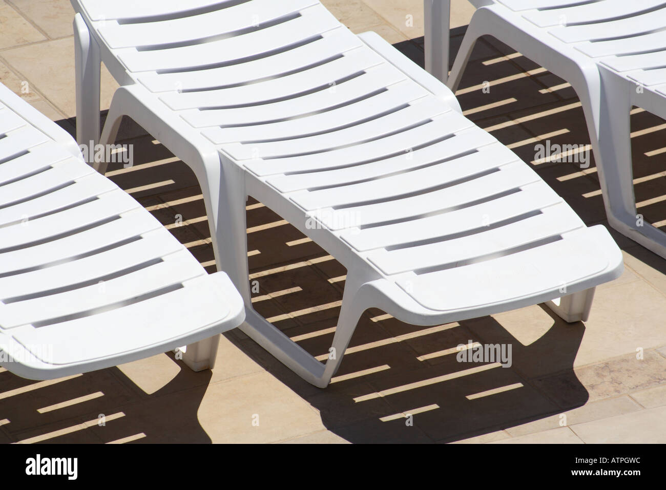 white plastic sunbeds Stock Photo - Alamy