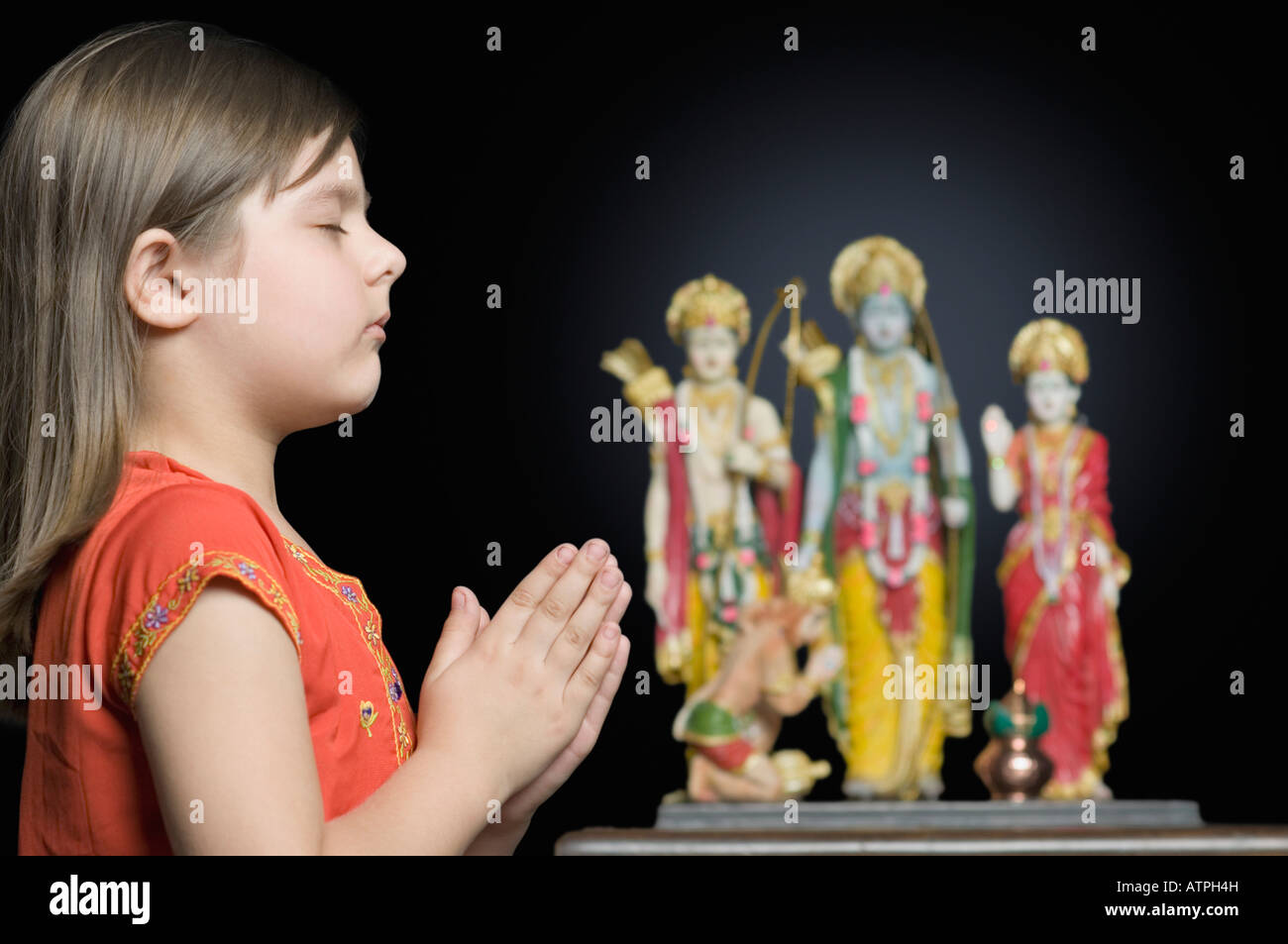 Side profile of a girl praying in front of a Hindu idol Stock Photo - Alamy