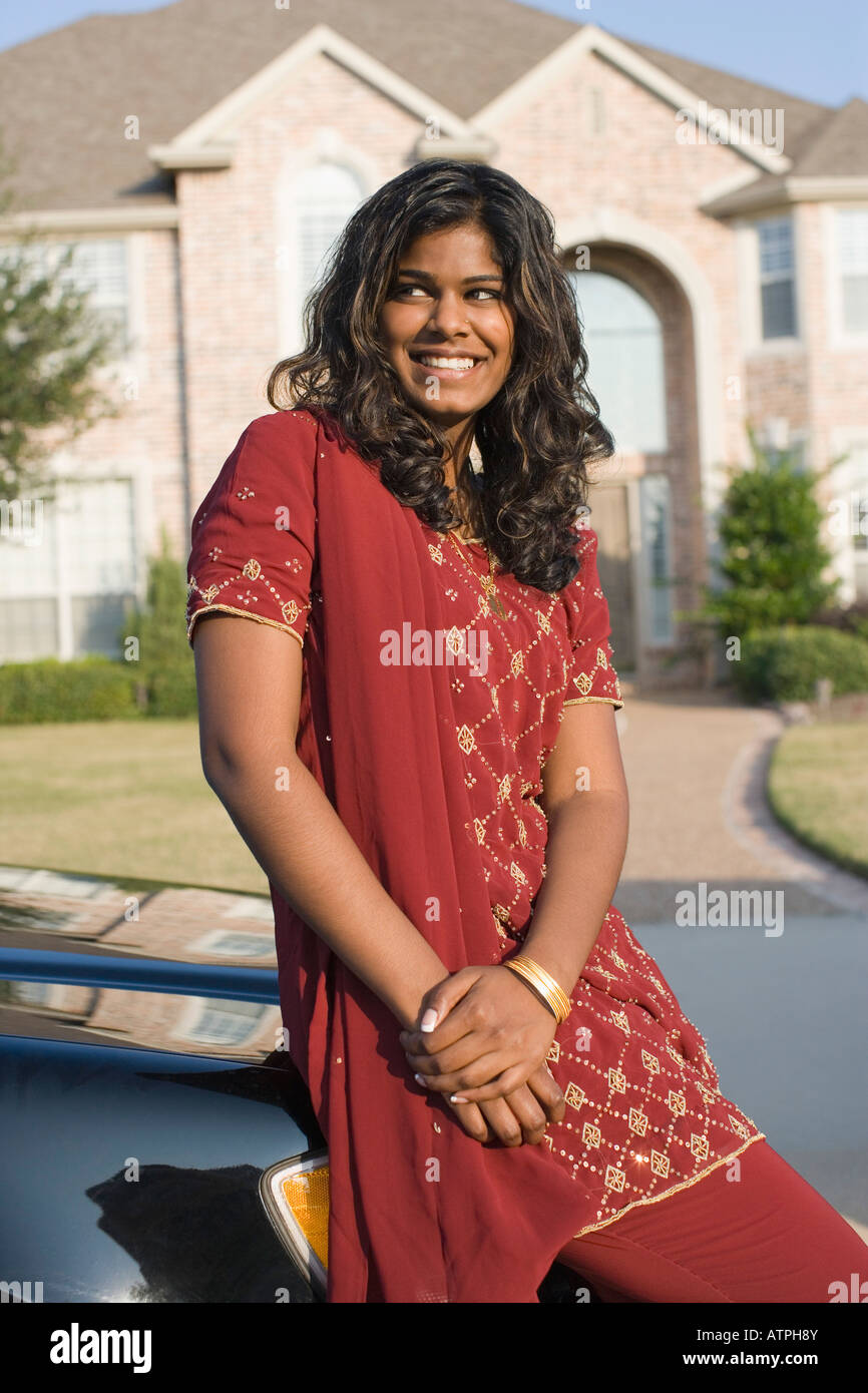 Young woman leaning against a car and smiling Stock Photo - Alamy