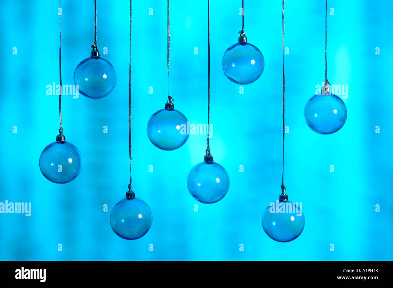 8 blue christmas baubles hanging on silver thread Stock Photo - Alamy