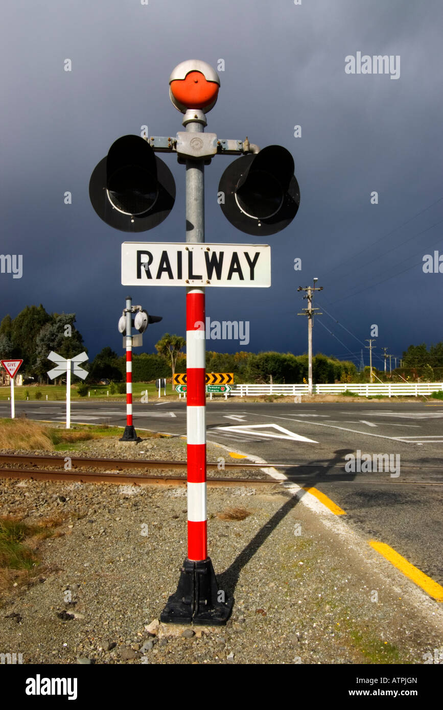 Lights, bell and sign at a railway crossing adjacent to a road junction ...