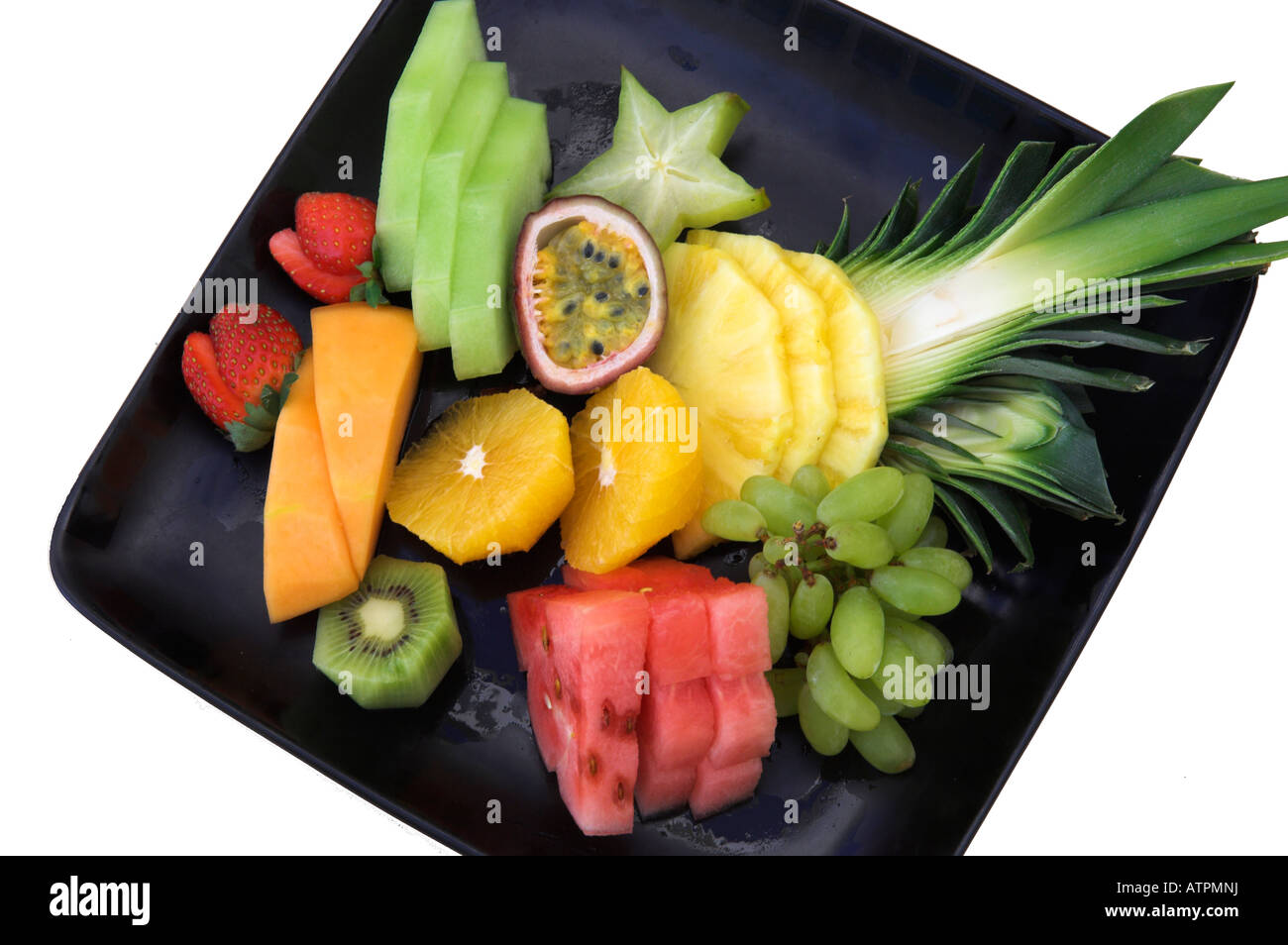 Sliced fresh tropical fruit on plate Stock Photo - Alamy