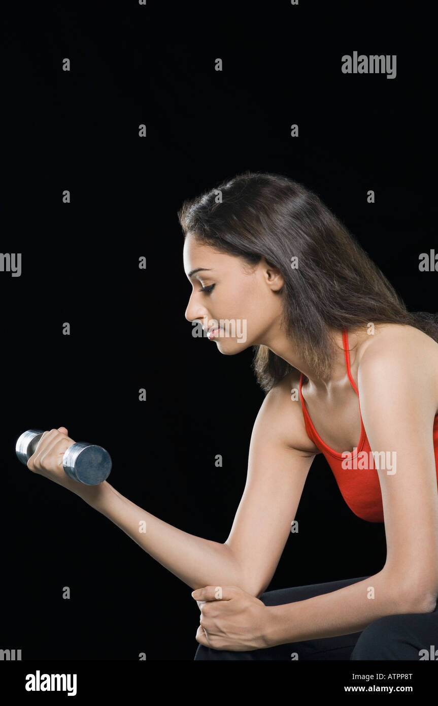 Side profile of a young woman exercising with a dumbbell Stock Photo ...