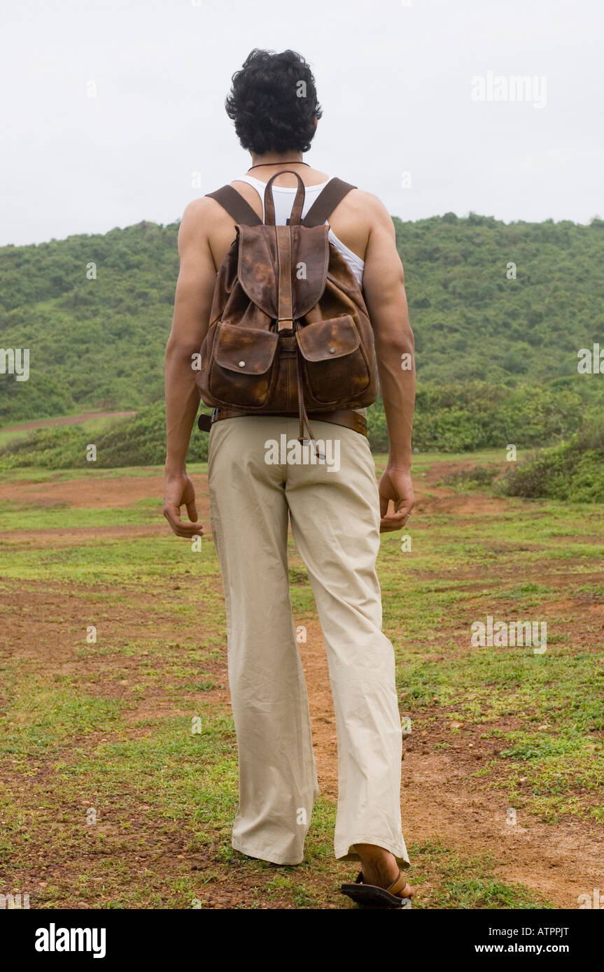 Rear view of a young man carrying a backpack on his back Stock Photo ...
