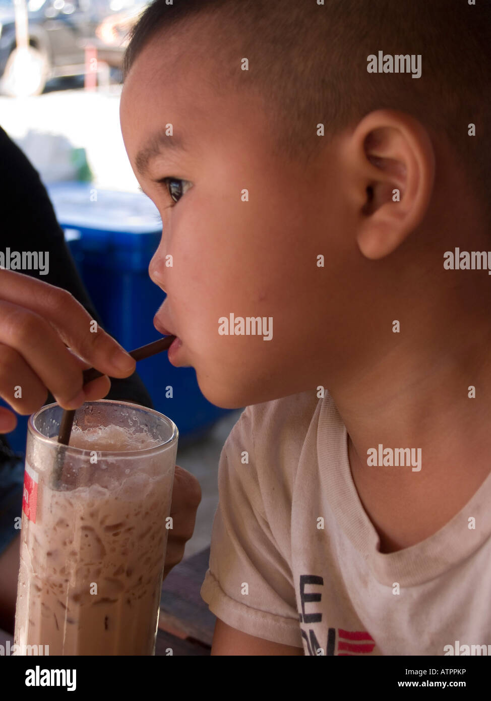 Thai boy sipping his drink Stock Photo - Alamy
