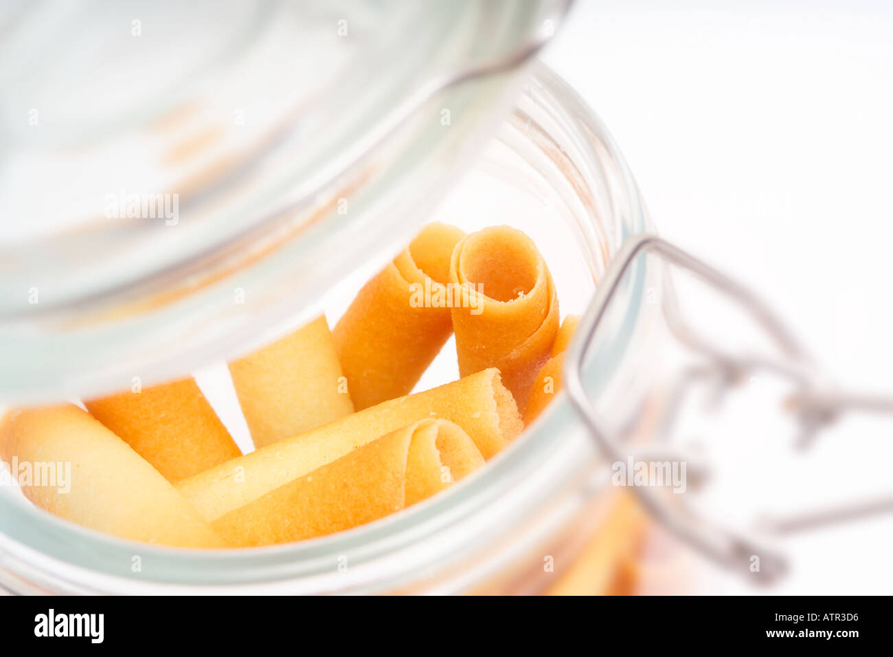 Glass jar full of biscuit curls against white background Stock Photo ...