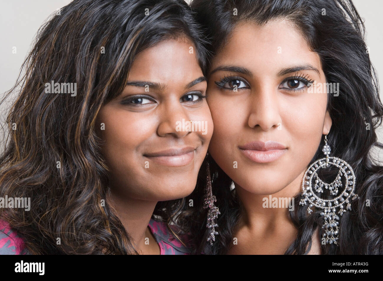 Close-up of two young women smirking Stock Photo - Alamy
